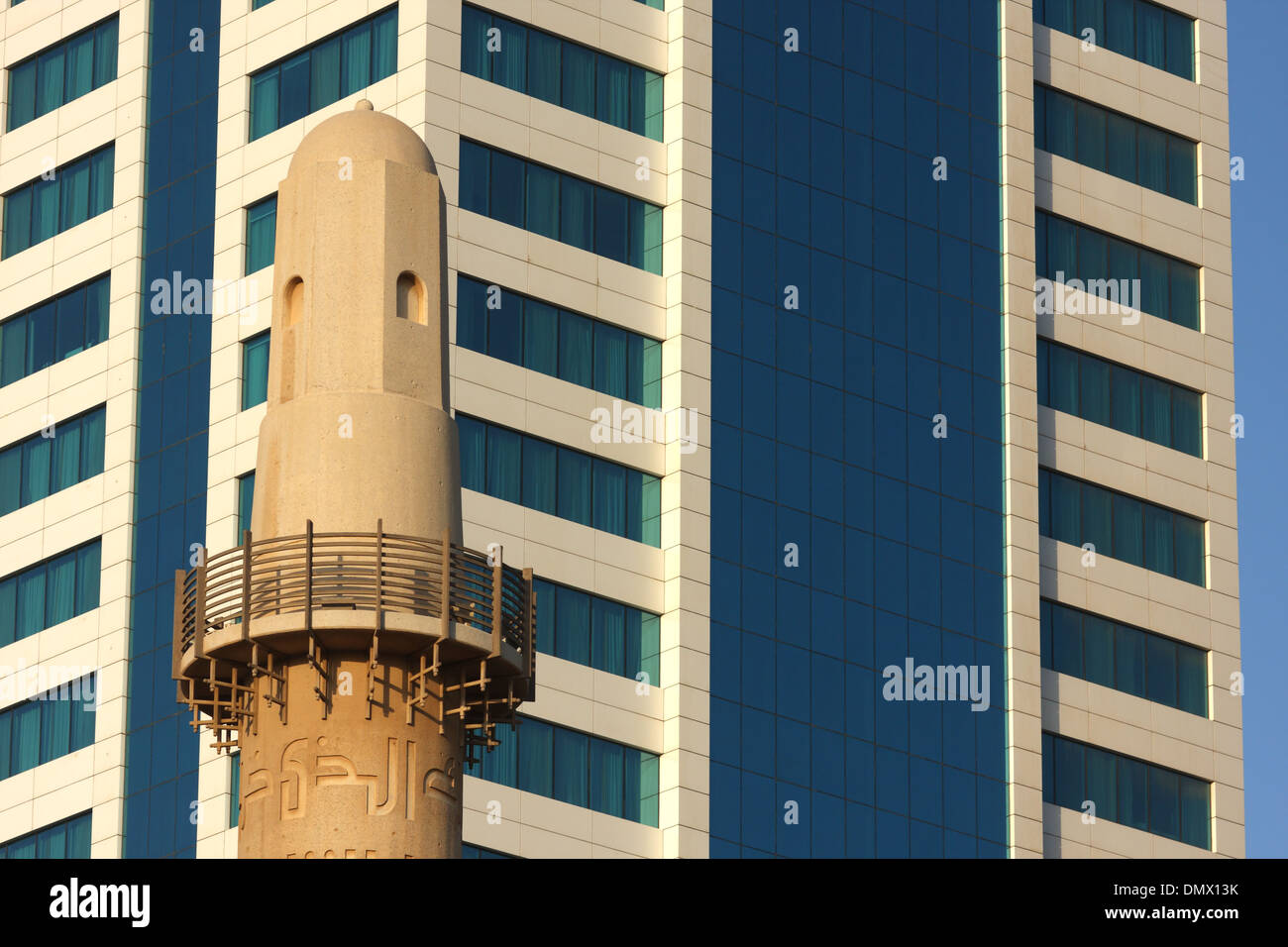 Minaret of the Beit al-Quran seen against the facade of a modern office ...