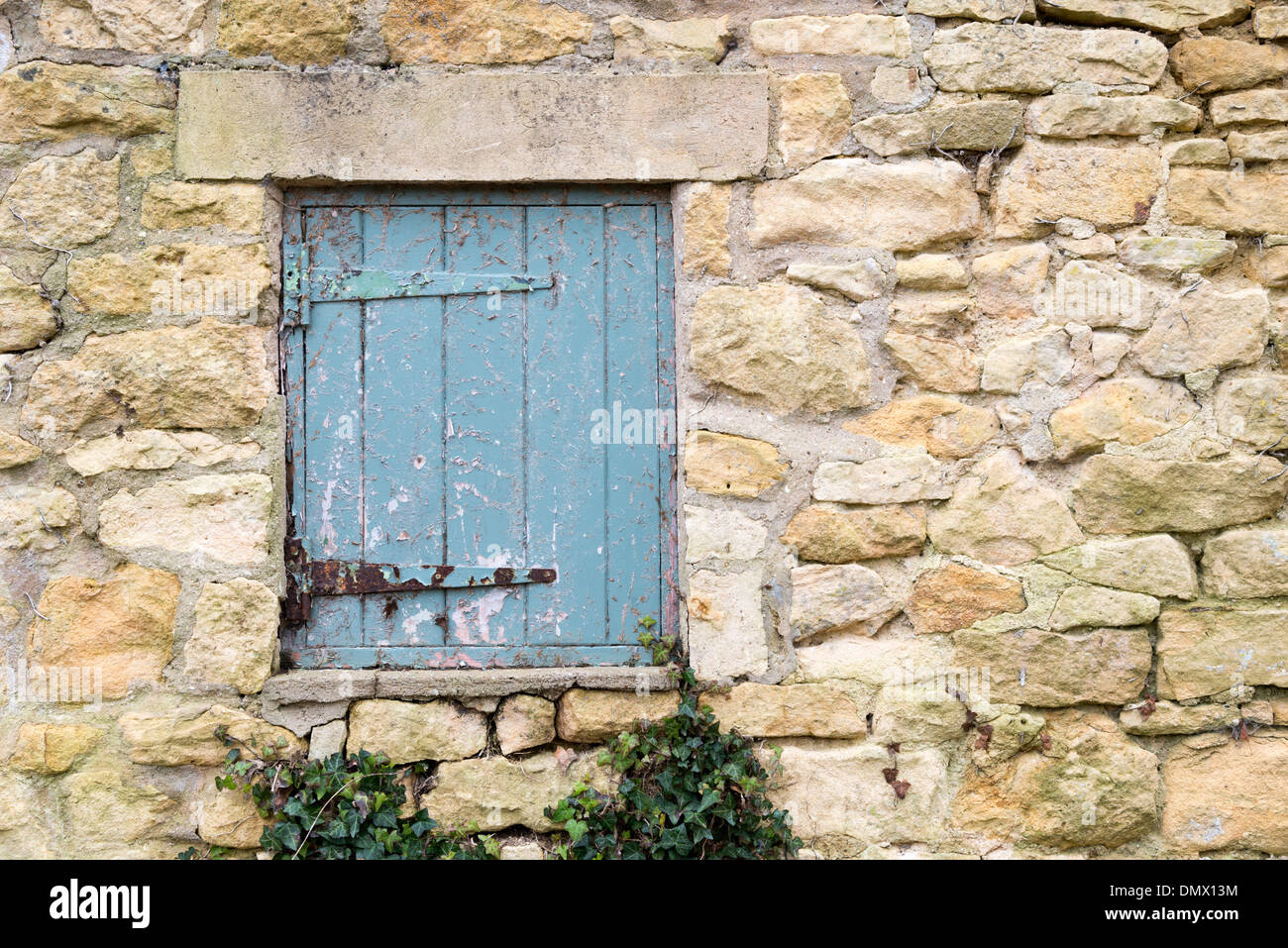A cotswold limestone house wall and shuttered window Stock Photo - Alamy