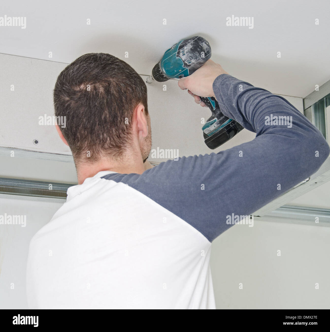 Builder mounting gypsum plasterboard frame on the wall Stock Photo - Alamy