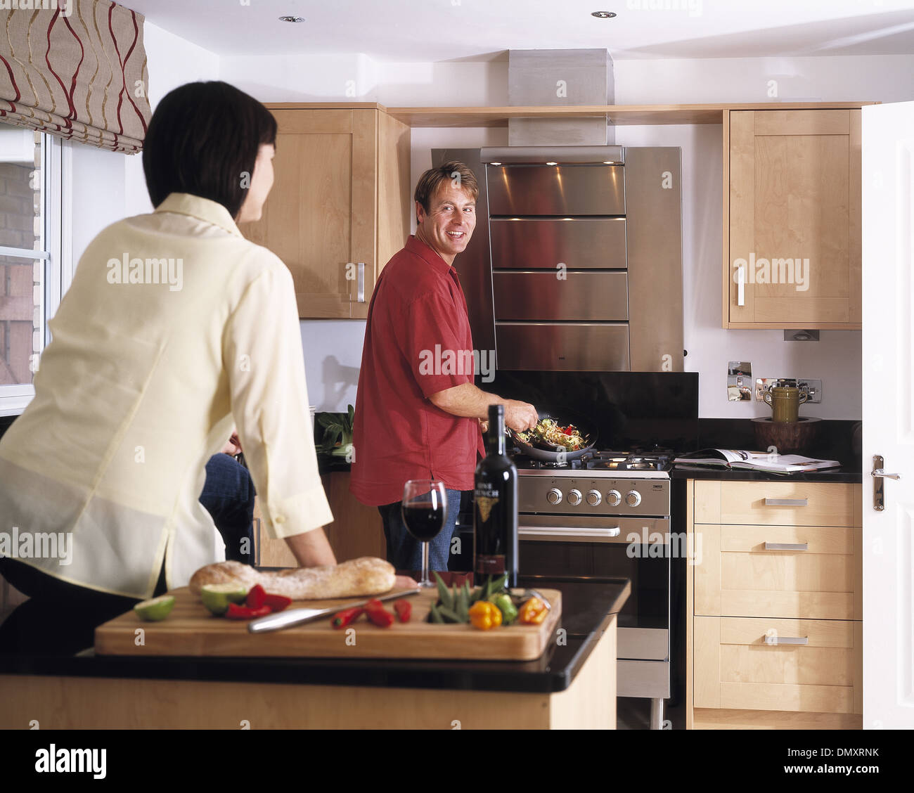 Couple preparing a meal in the kitchen Stock Photo - Alamy