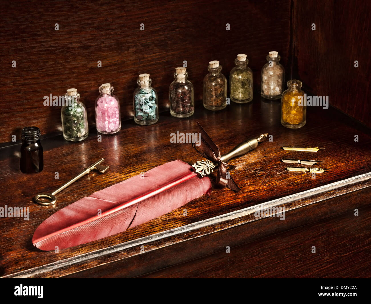 old fashioned feather pen, ink, skeleton key and mineral jars on old ...