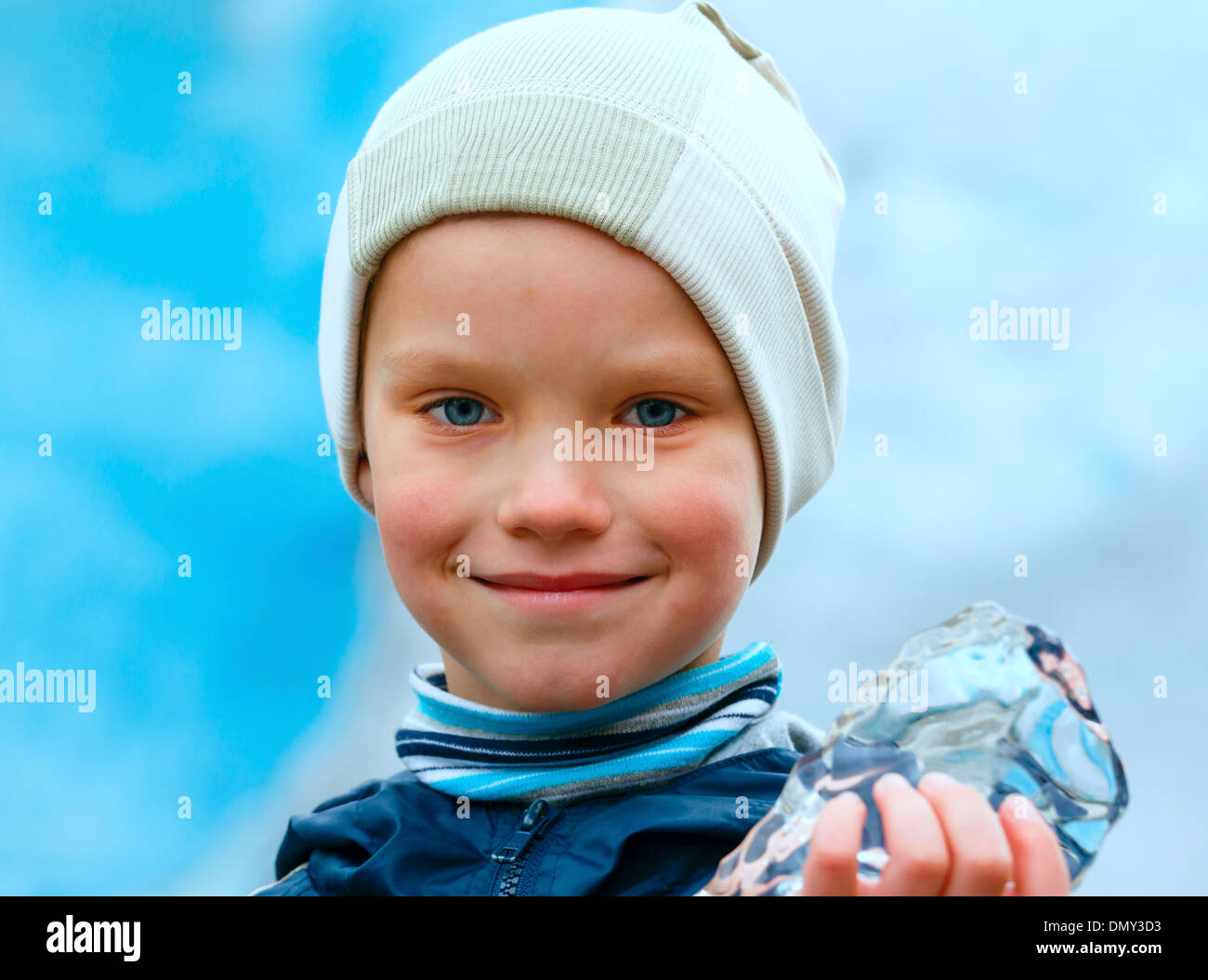 Portrait happy boy with piece of ice in hand on Nigardsbreen glacier ...