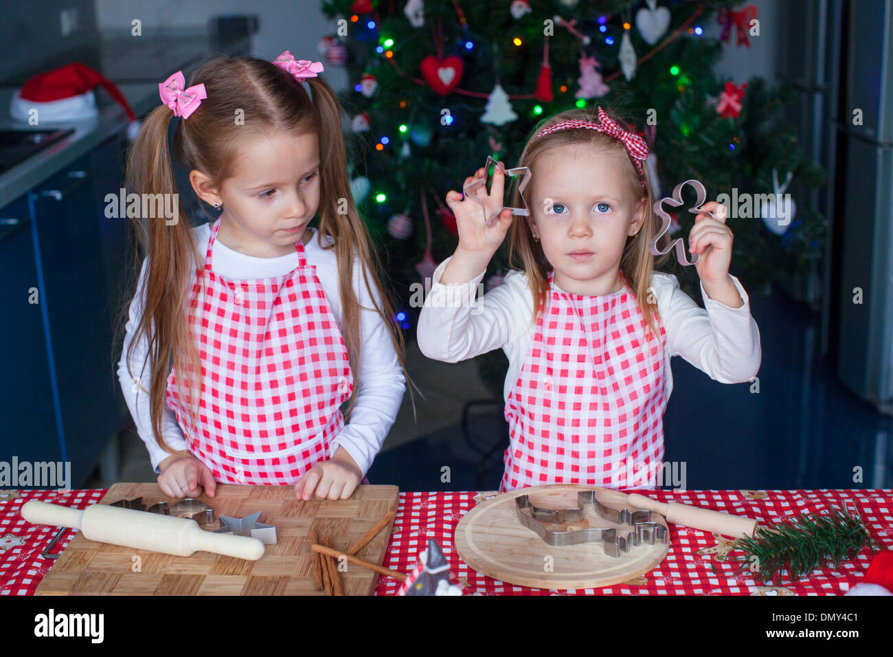 Cute little girls baking ginger cookies for Christmas at kitchen Stock ...