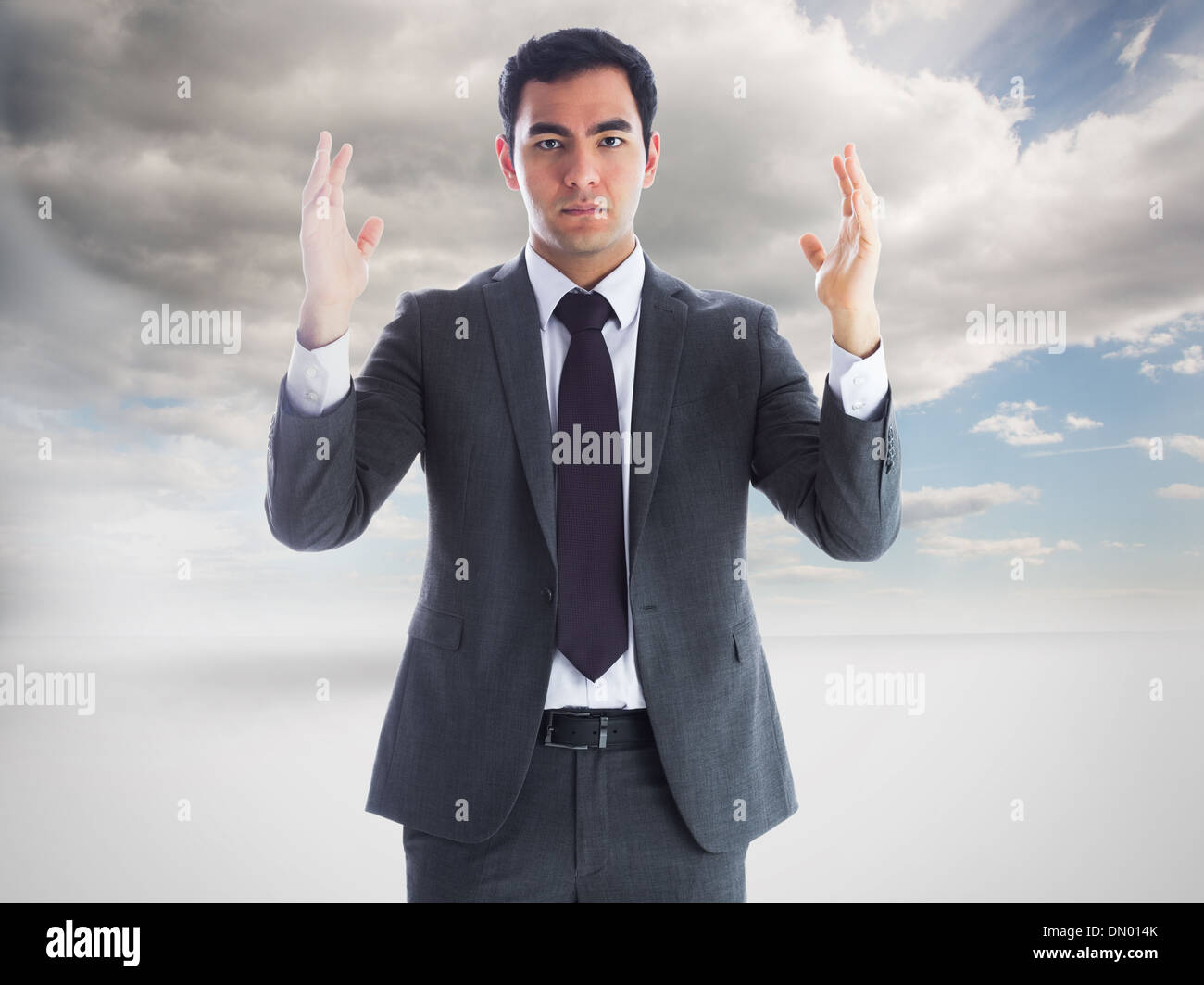 Composite image of unsmiling businessman with arms raised Stock Photo ...