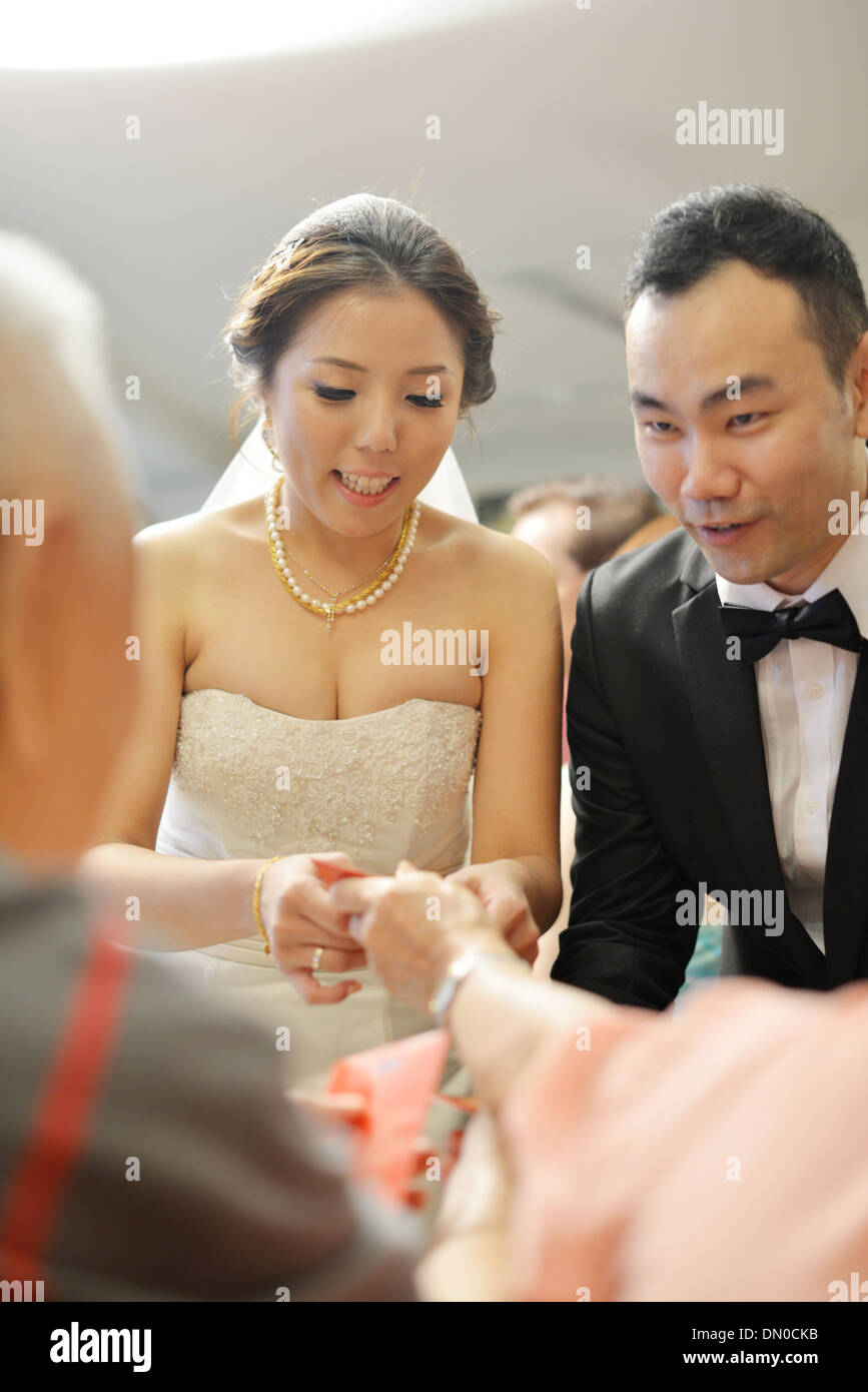 Traditional Chinese wedding, bride and groom receiving gift from elders ...