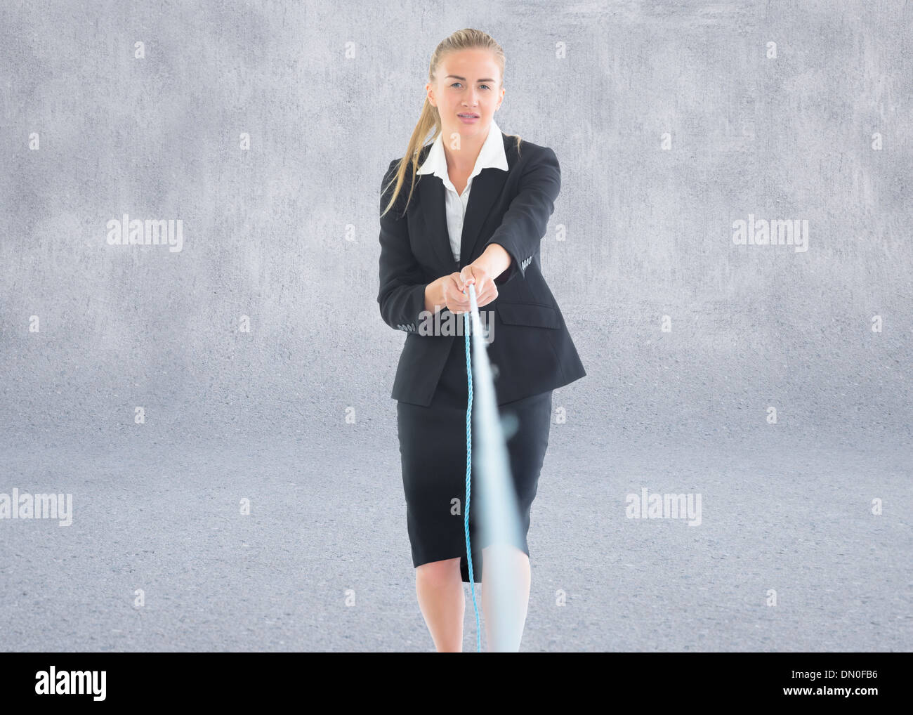 Composite image of businesswoman pulling a rope Stock Photo - Alamy