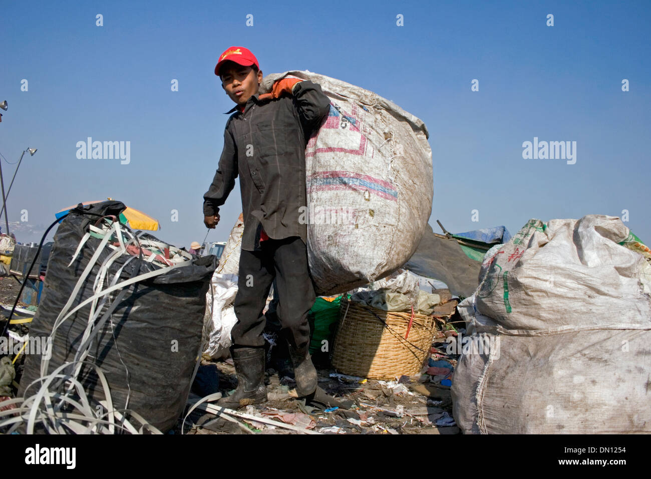 A young child laborer boy is carrying a large sack at the Stung ...