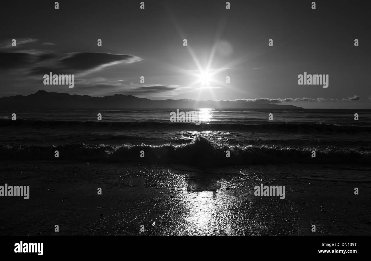 Dramatic sunburst with the shadow of a splashing wave on an Alaskan ...