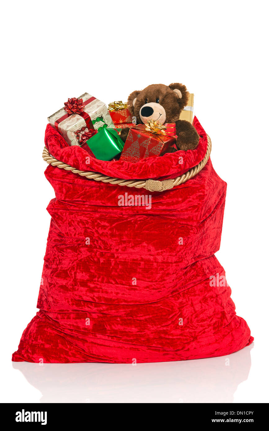 A red Christmas sack full of gift wrapped presents and a handmade bear ...