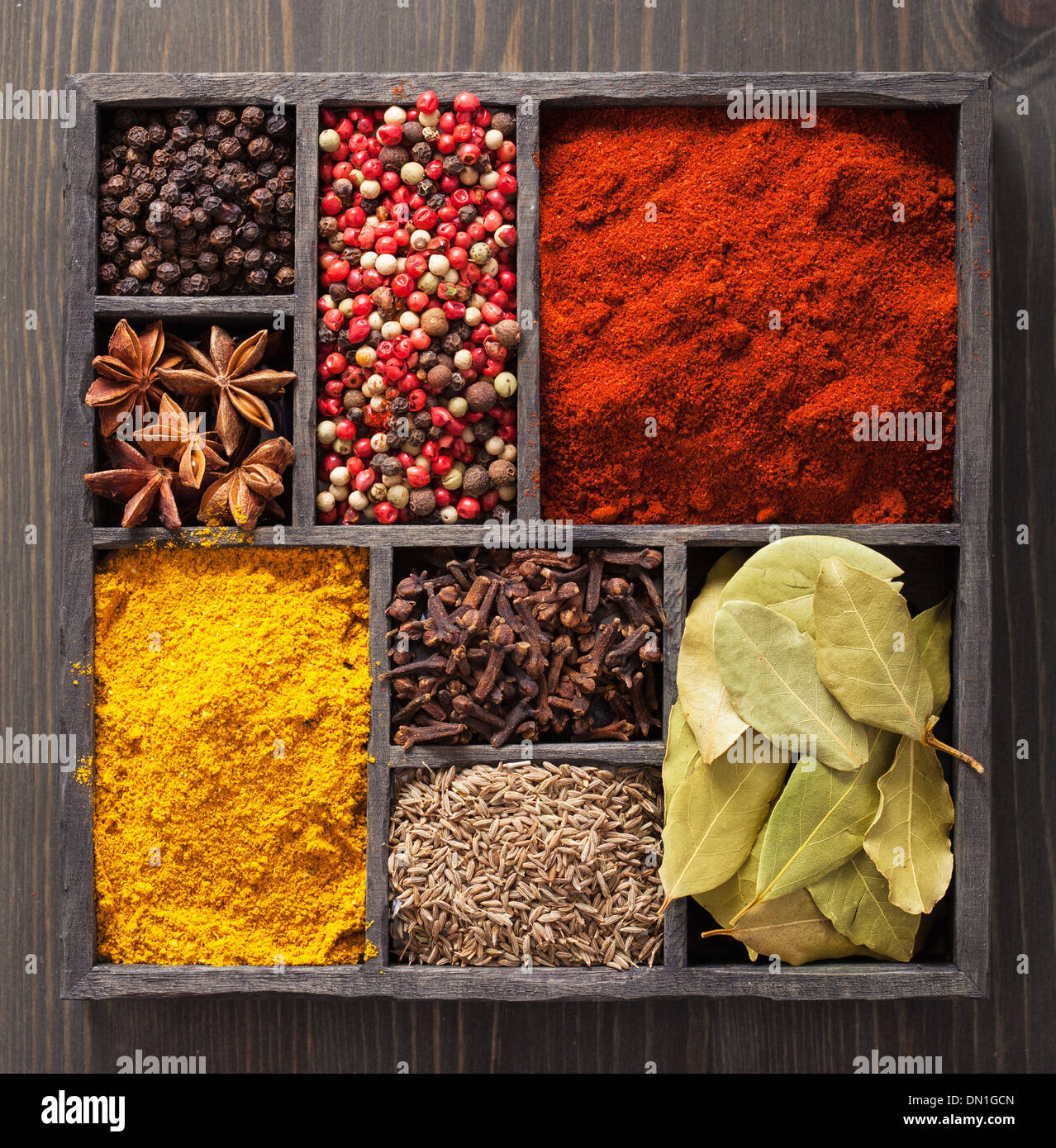 spices in box: pink and black pepper, paprika powder, curry, bay leaf ...
