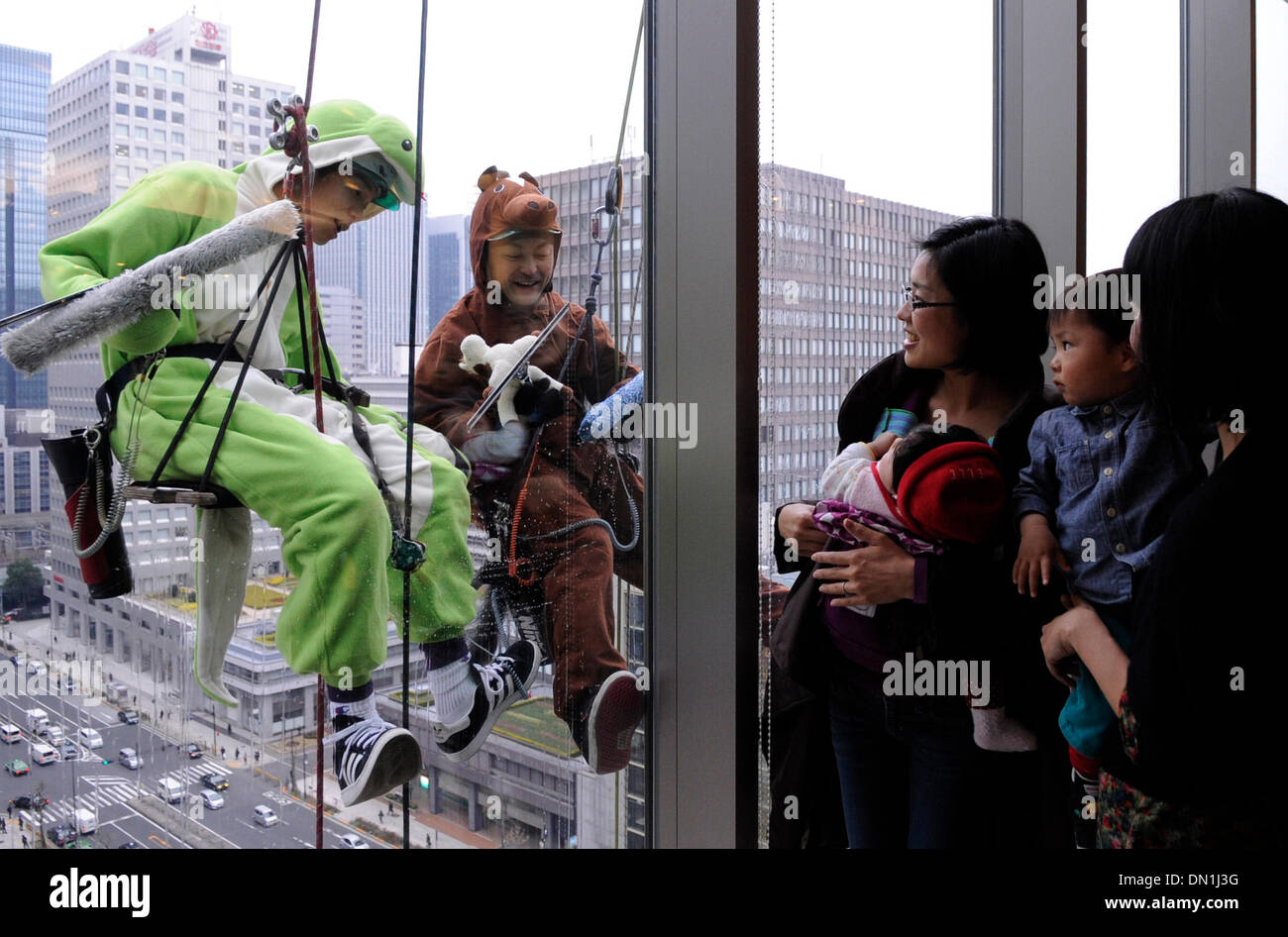 Tokyo, Japan. 18th Dec, 2013. Window cleaners clad in costumes of snake ...