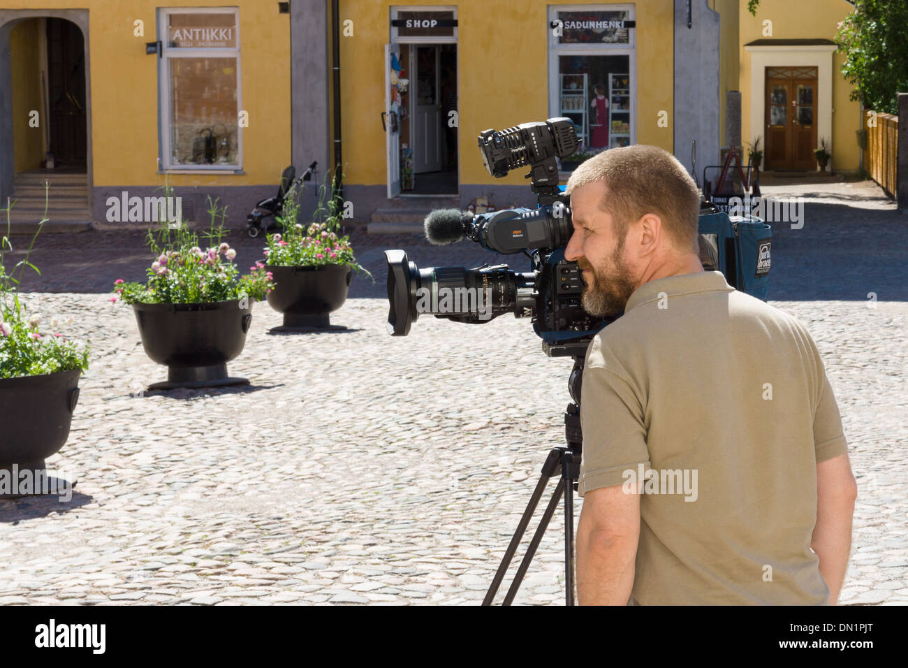 Operator with a video camera and tripod Stock Photo - Alamy