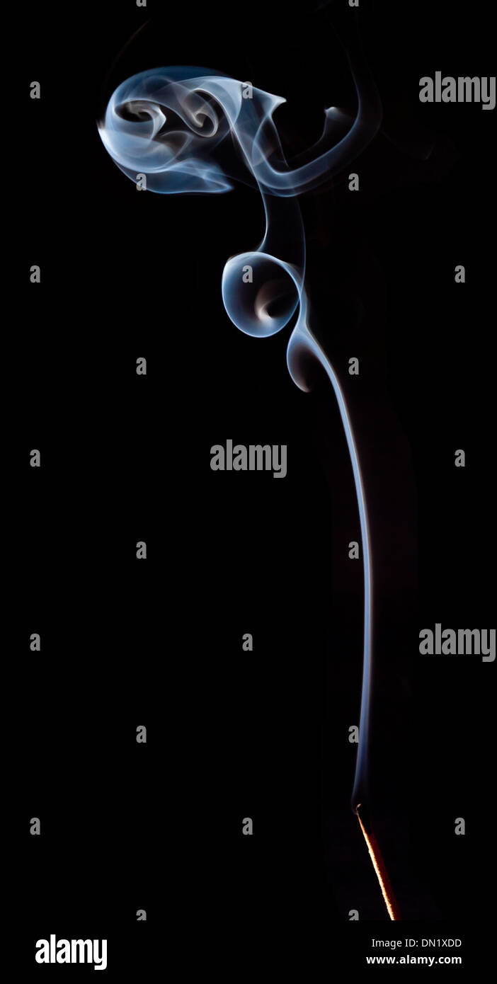 Smoking incense isolated to black background Stock Photo - Alamy