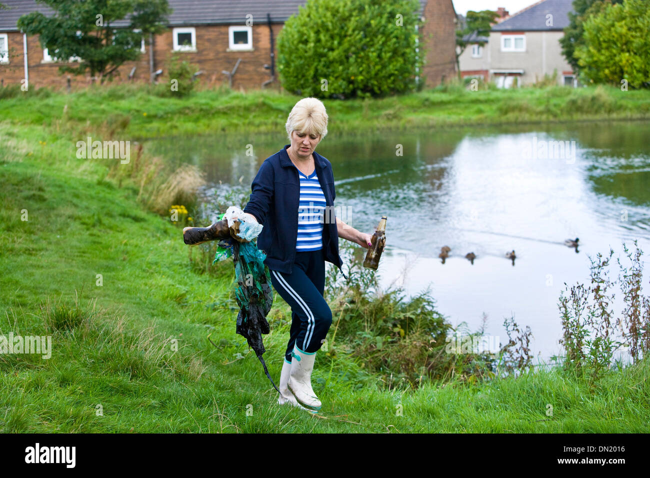 volunteer removing rubbish from a pond Stock Photo - Alamy