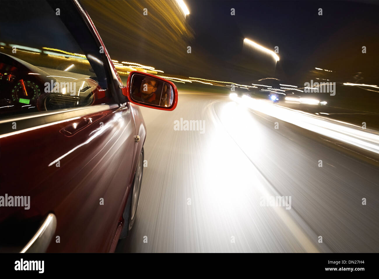 A man driving a car round a bend at night Stock Photo - Alamy