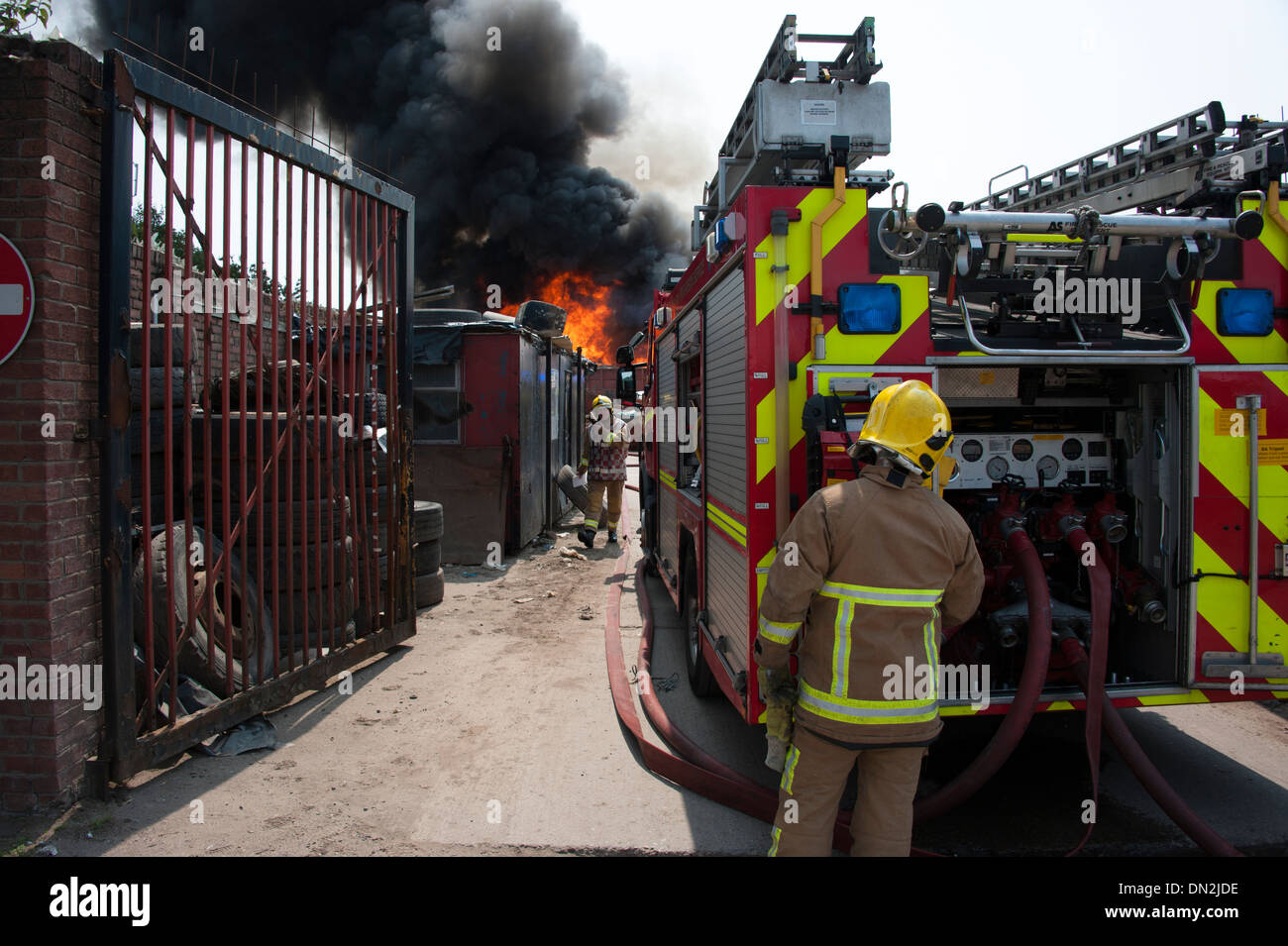 Firefighters at large industrial fire flames smoke huge Stock Photo - Alamy