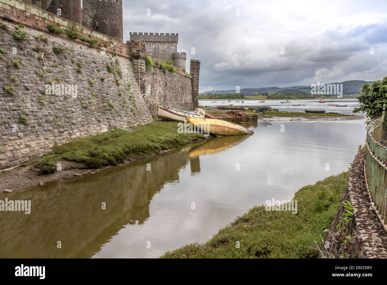 River Conwy with small boats on grass bank, one boat on its side. along ...