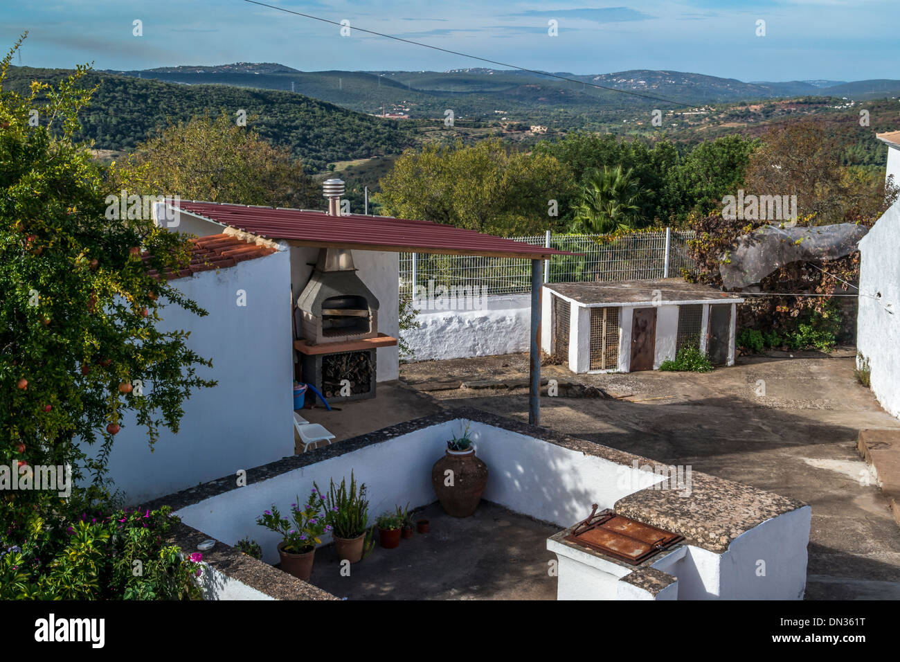 BBQ in a garden with a red cove over the top, looking out over a valley ...