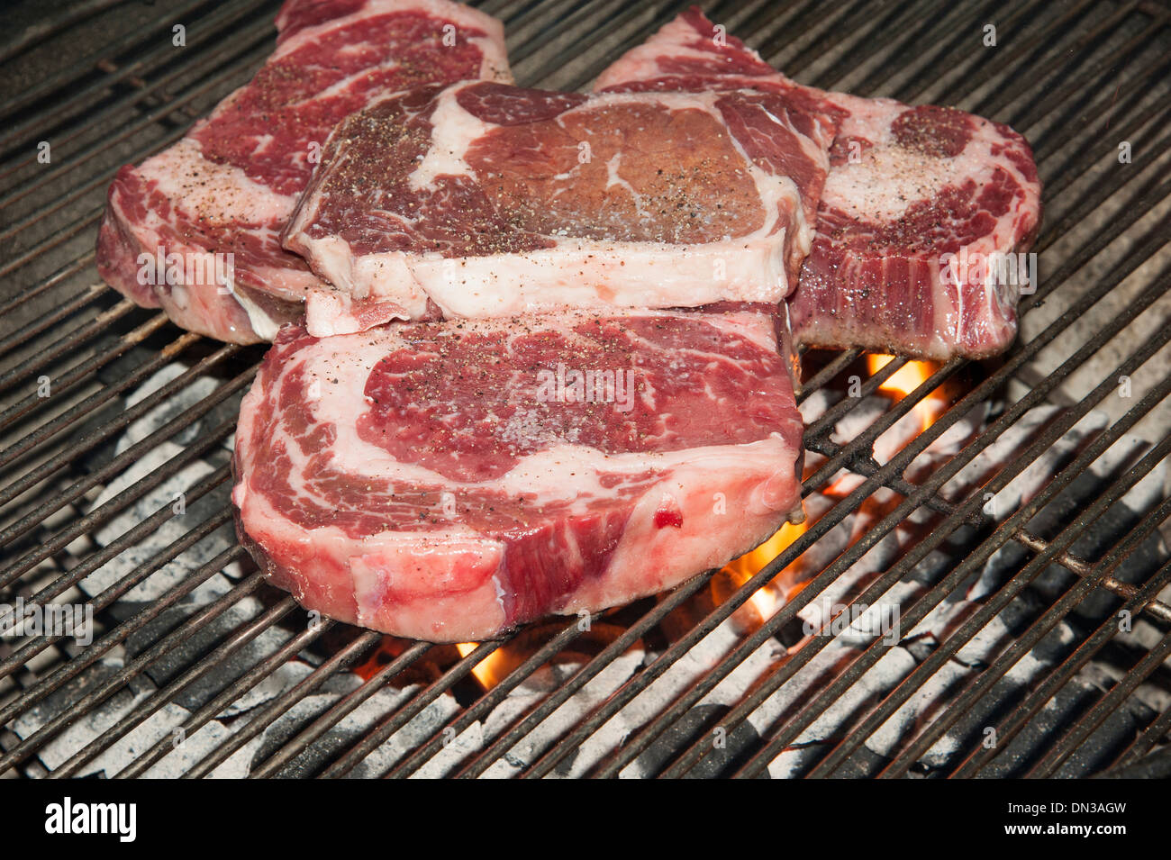 American Ribeye steaks cooking over coals on a barbecue Stock Photo - Alamy