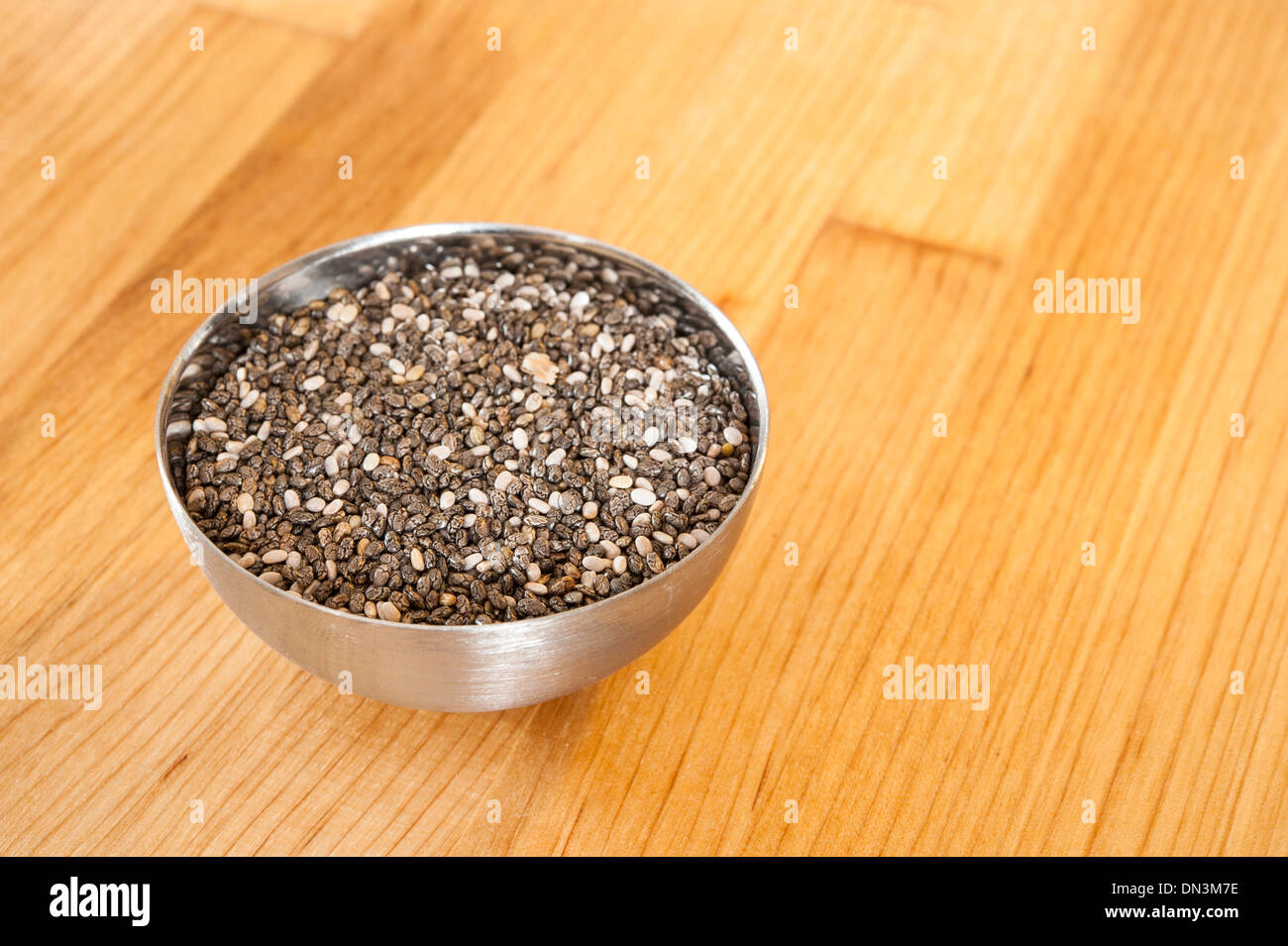 Silver dish of chia seed on a wood counter Stock Photo - Alamy