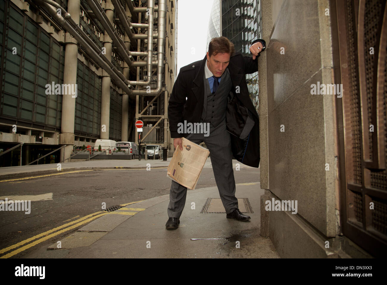 A businessman vomiting in the street by the Lloyds building in the City ...