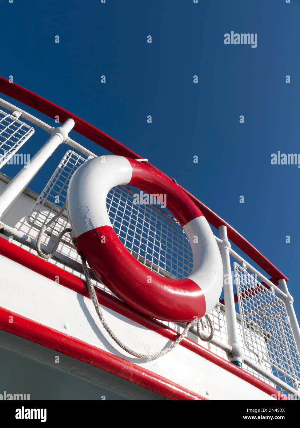 Bright red and white life-saver hanging off a boat's rail Stock Photo ...