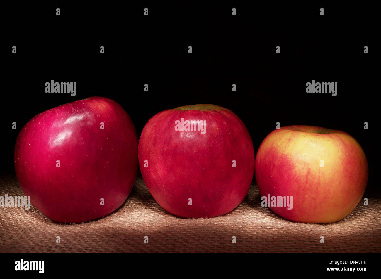 Three red apples on black background still life Stock Photo - Alamy