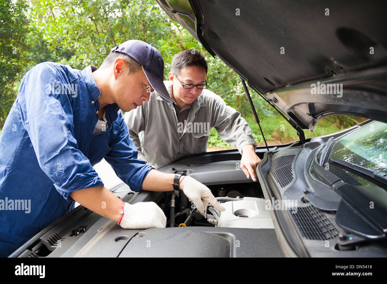 two Mechanics fixing the car on the road Stock Photo - Alamy