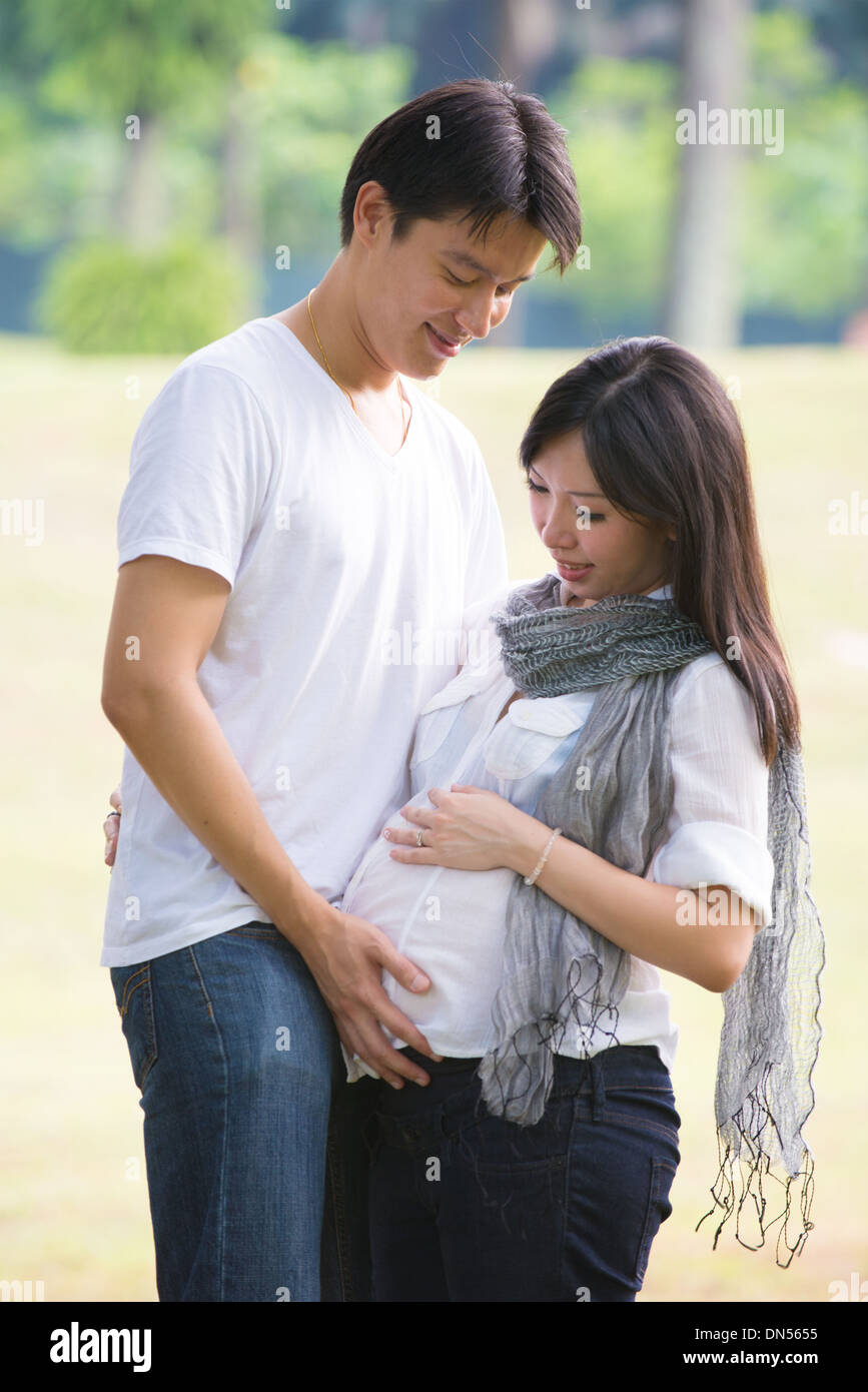 Happy young pregnant asian couple in the nature Stock Photo - Alamy
