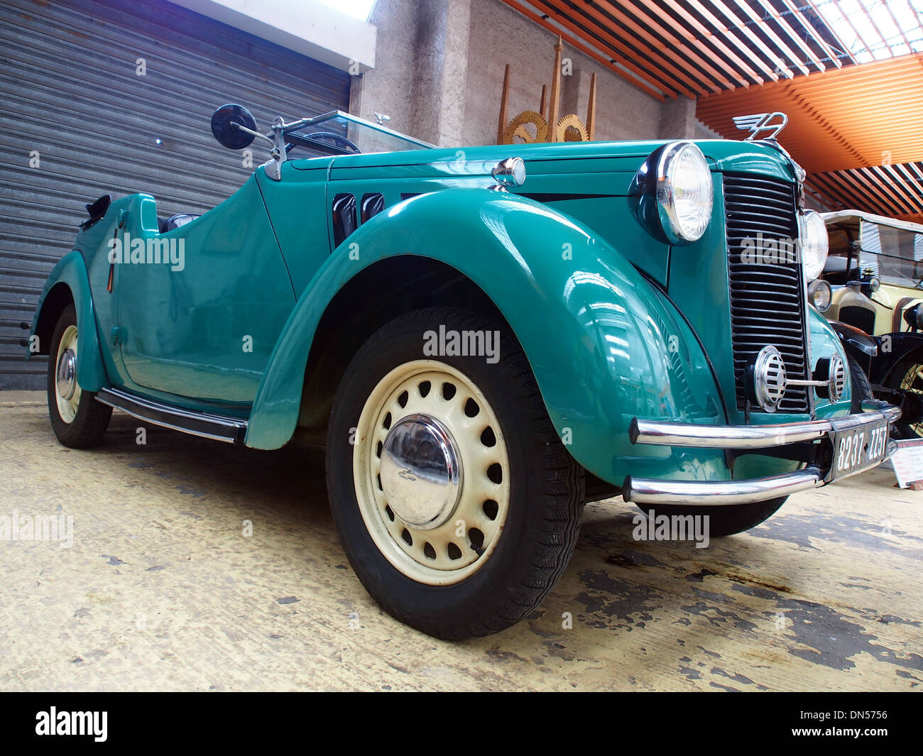 This image shows a green Austin convertible car, a classic example of ...