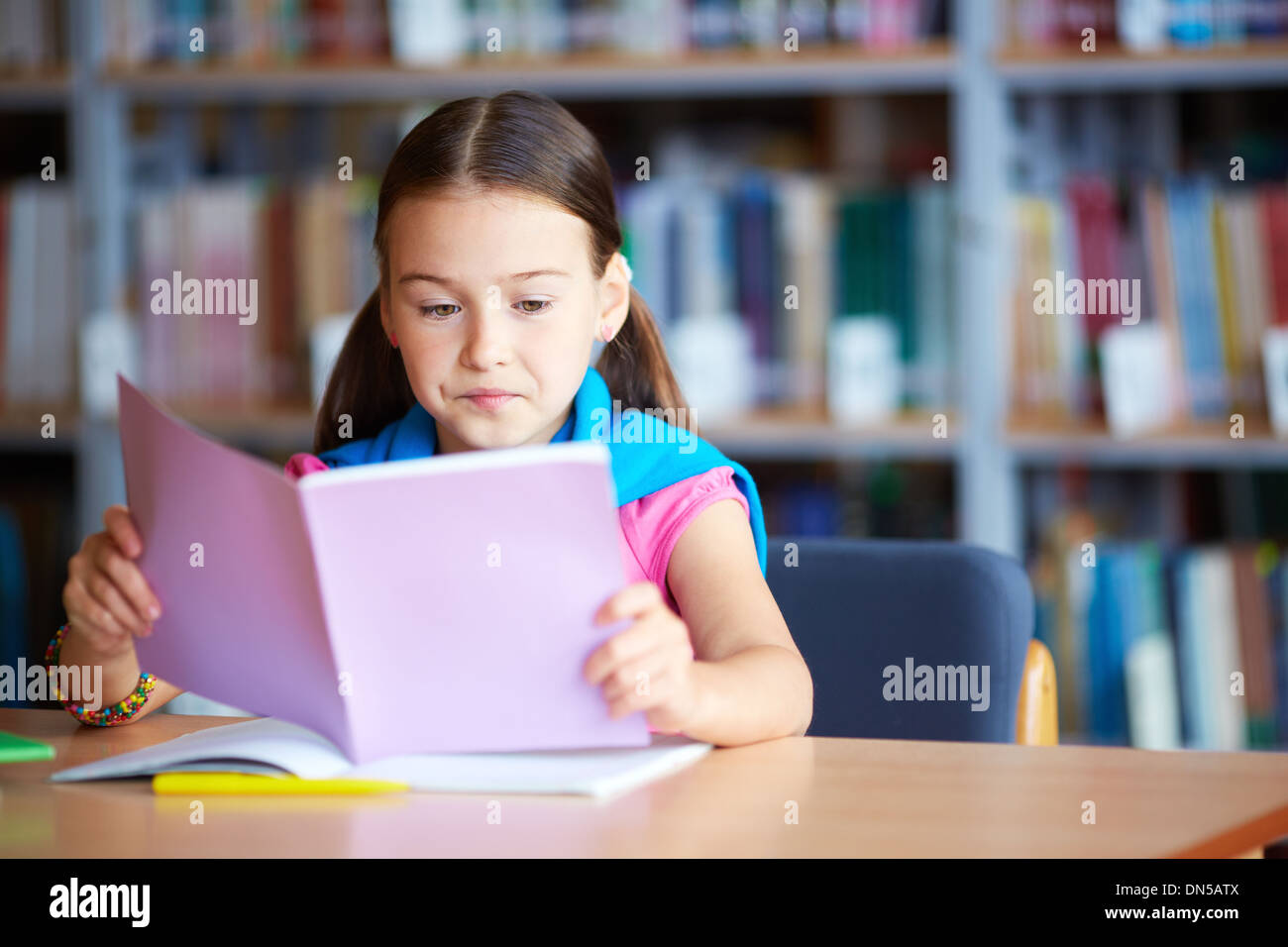 Portrait of a lovely girl reading in library Stock Photo - Alamy