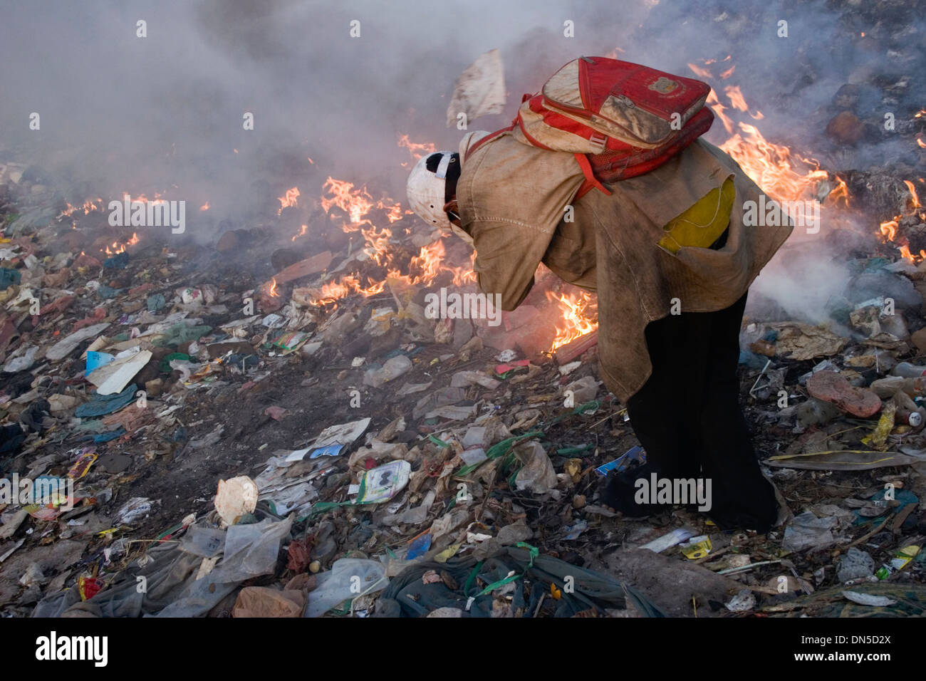 A young child laborer boy is trying to put out a fire at the Stung ...