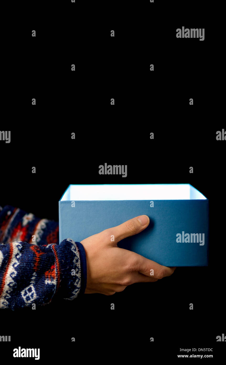 two hands holding a blue box before black background Stock Photo - Alamy