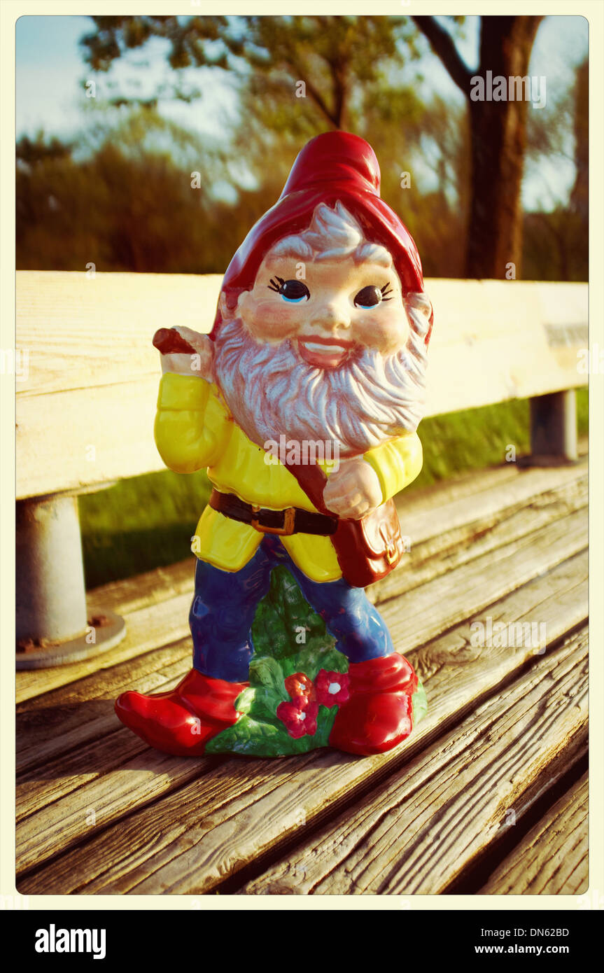 Gnome figurine on park bench Stock Photo - Alamy