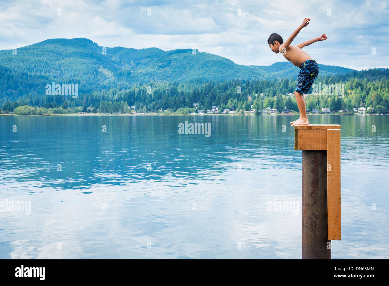 Korean boy jumping off platform into lake Stock Photo - Alamy