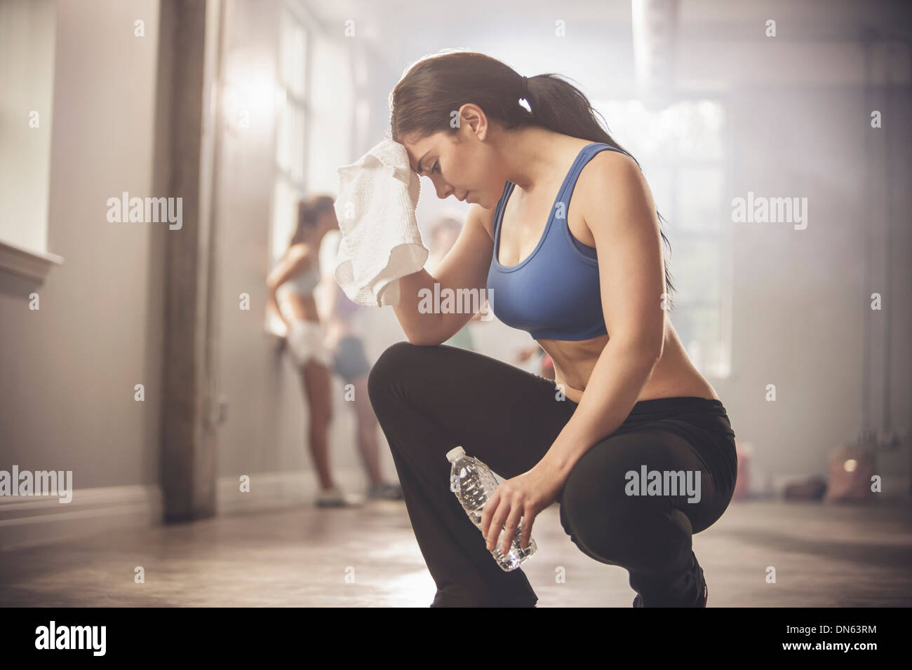 Woman wiping sweat with towel in gym Stock Photo - Alamy
