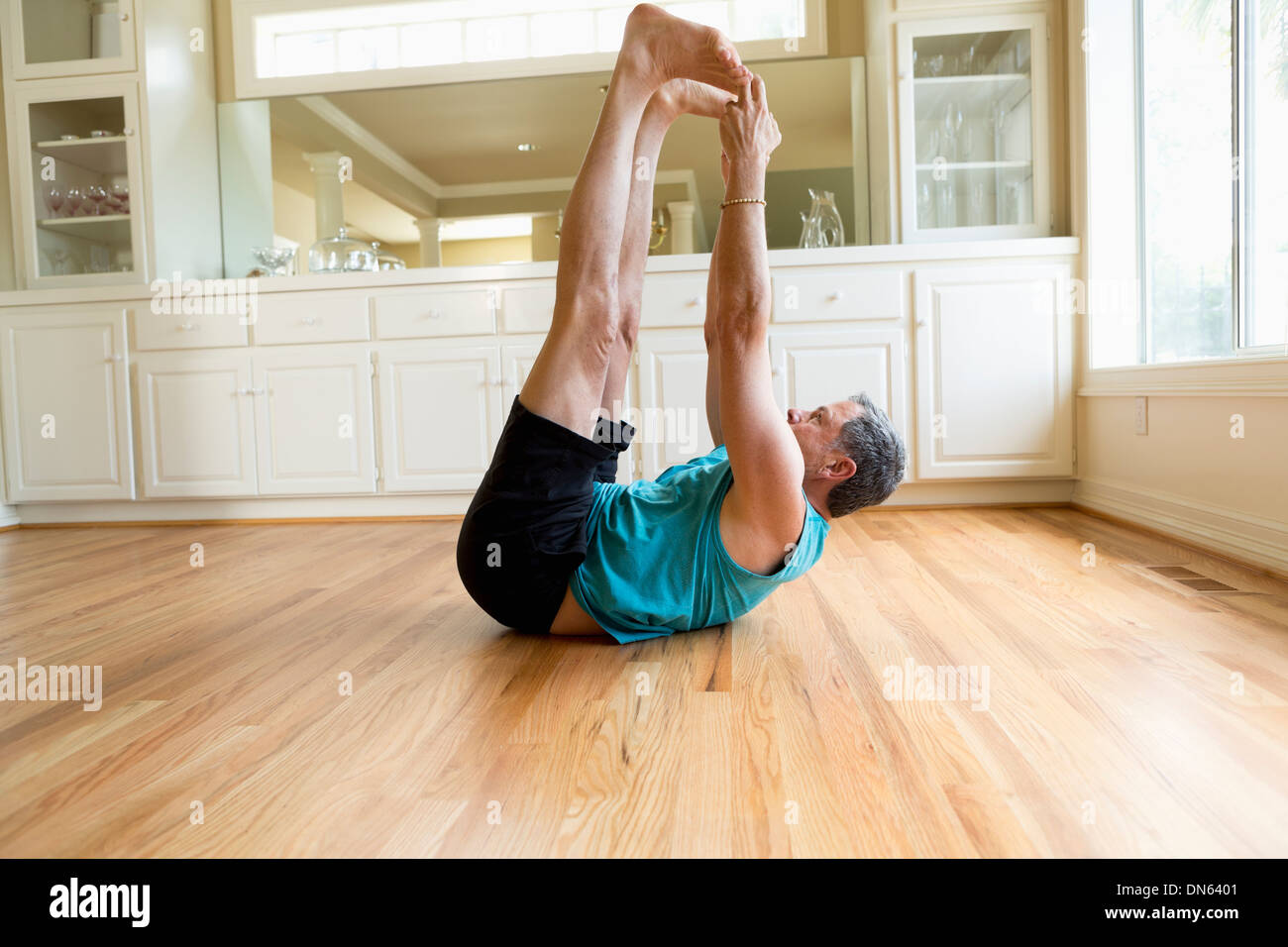 Caucasian man stretching in home Stock Photo - Alamy
