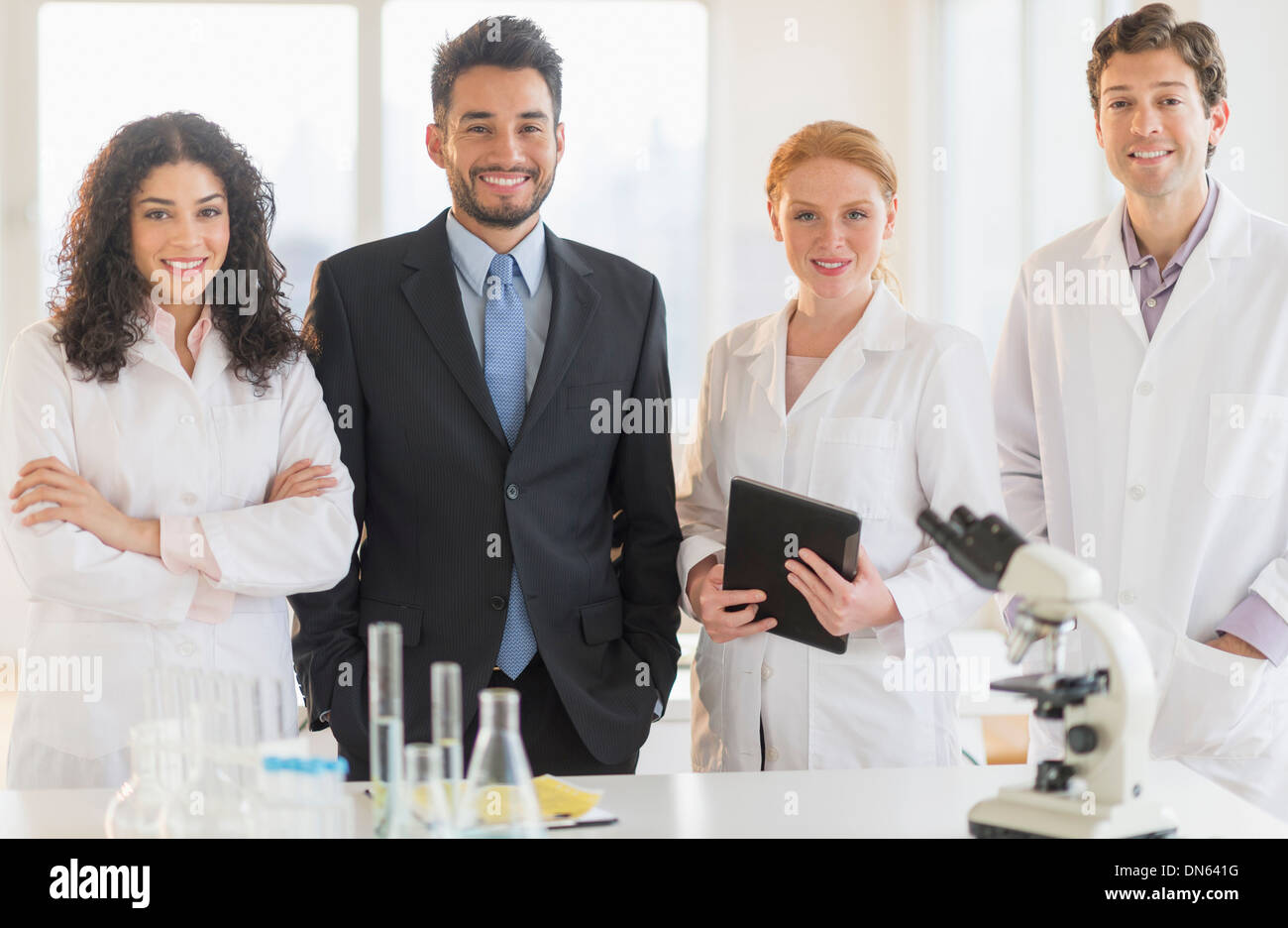 Scientists and businessman smiling in laboratory Stock Photo - Alamy