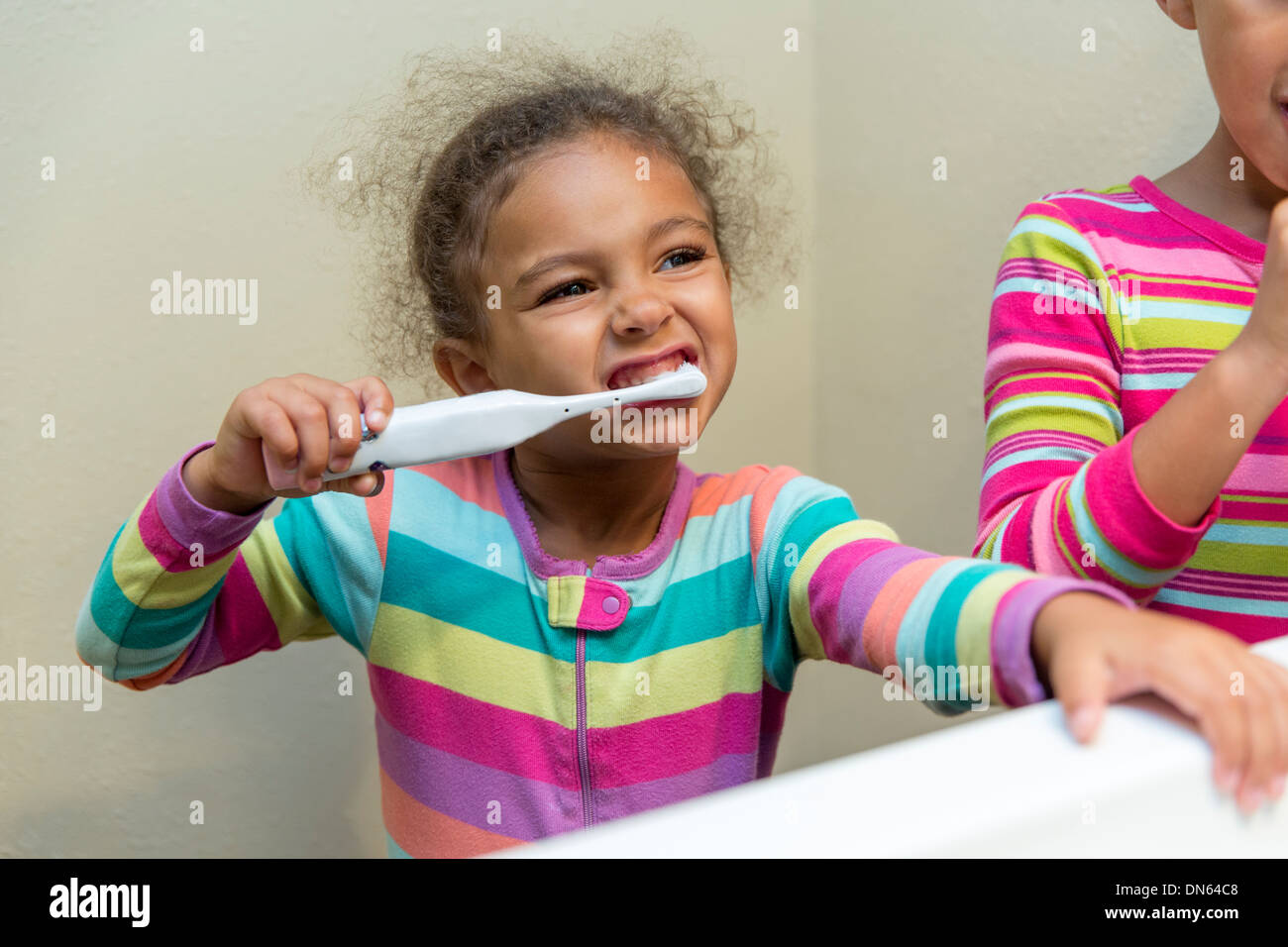 Mixed race girls brushing their teeth Stock Photo - Alamy