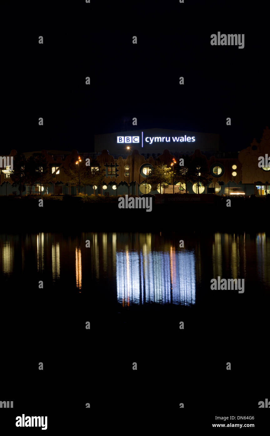 The illuminated BBC Roath Lock studios besides Roath Basin Cardiff Bay ...