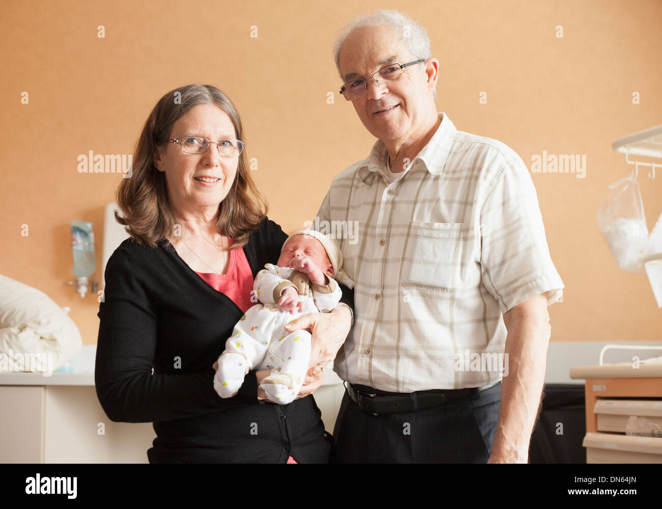 Senior Caucasian couple holding newborn grandson Stock Photo - Alamy