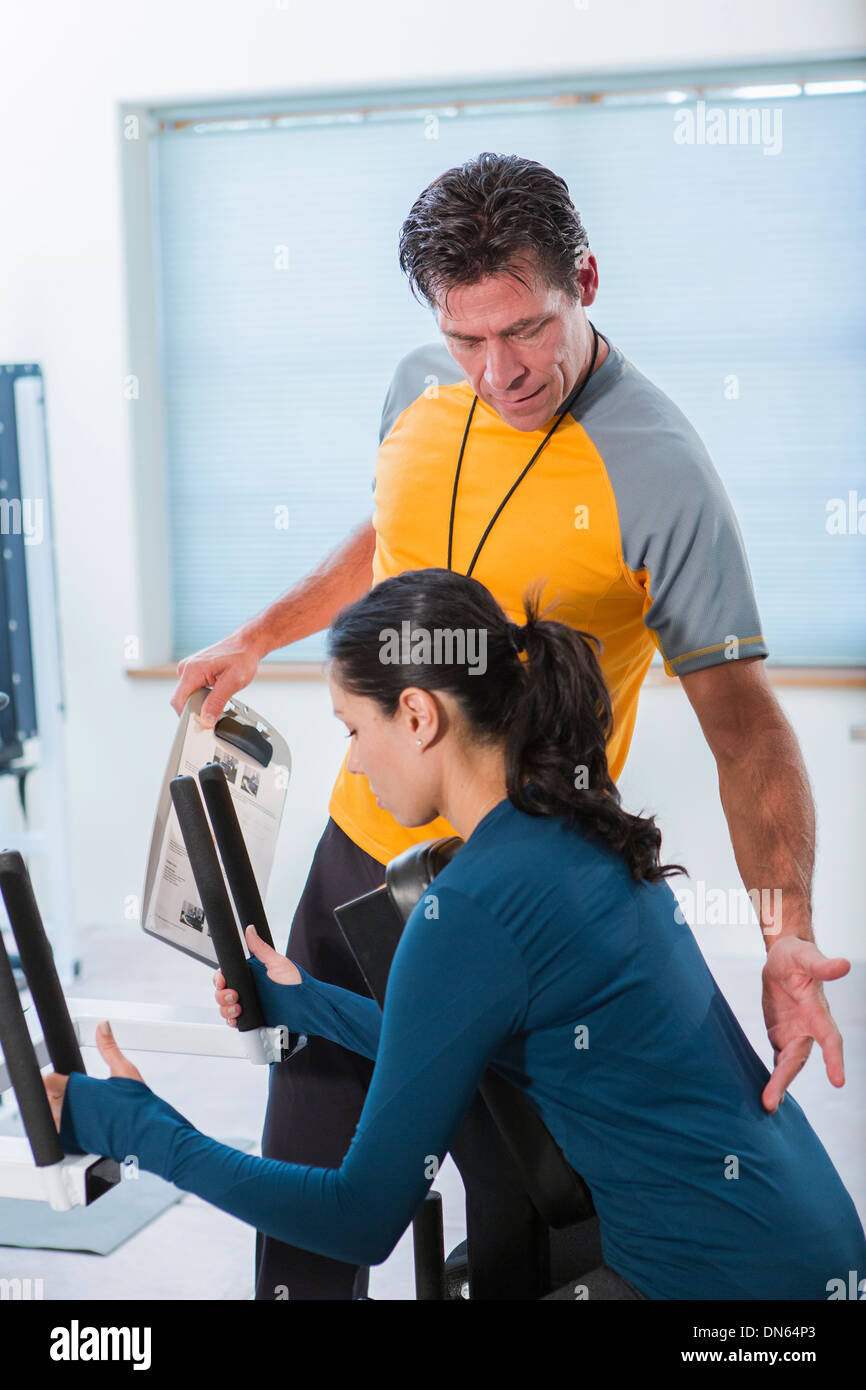 Personal trainer explaining young woman hi-res stock photography and ...