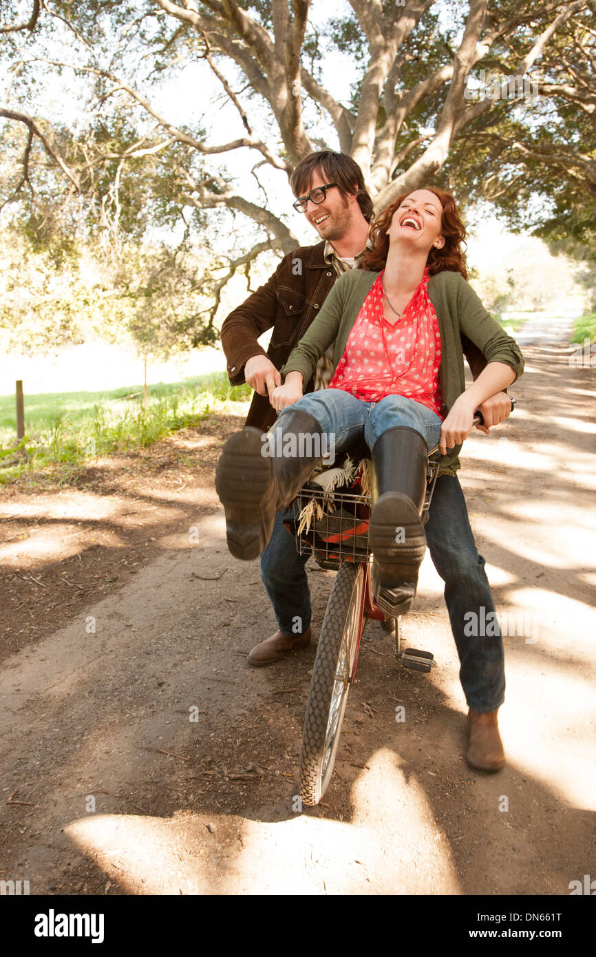 Couple riding bicycle on rural road Stock Photo - Alamy