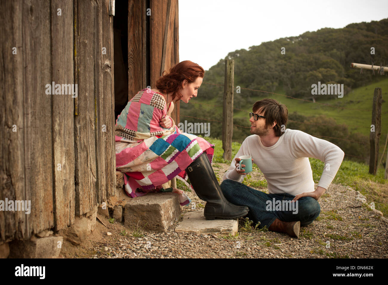 Couple relaxing by barn Stock Photo - Alamy