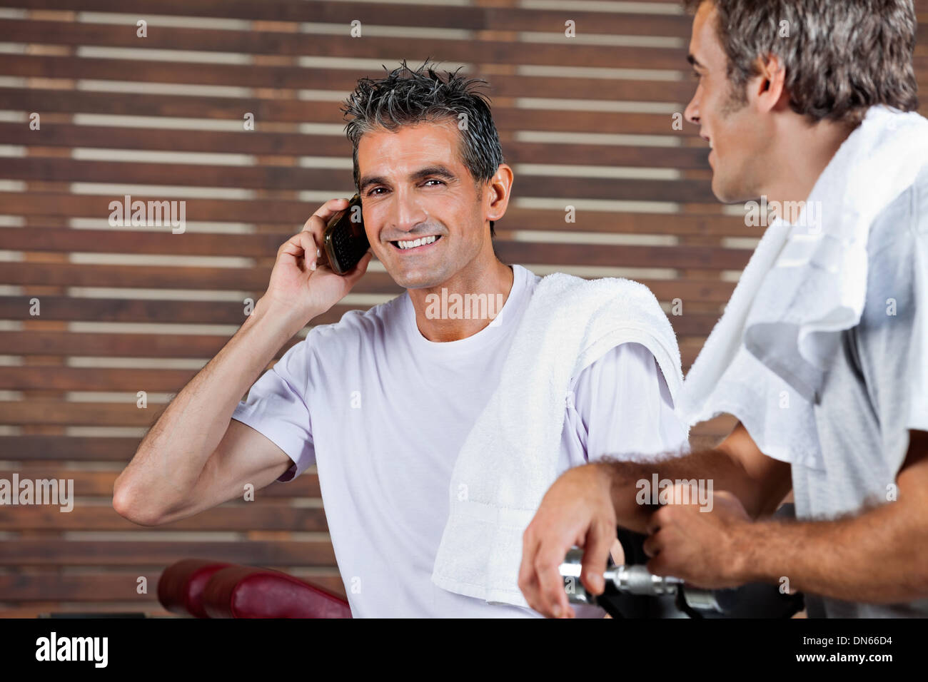 Man On Call While Friend Looking At Him In Health Club Stock Photo - Alamy