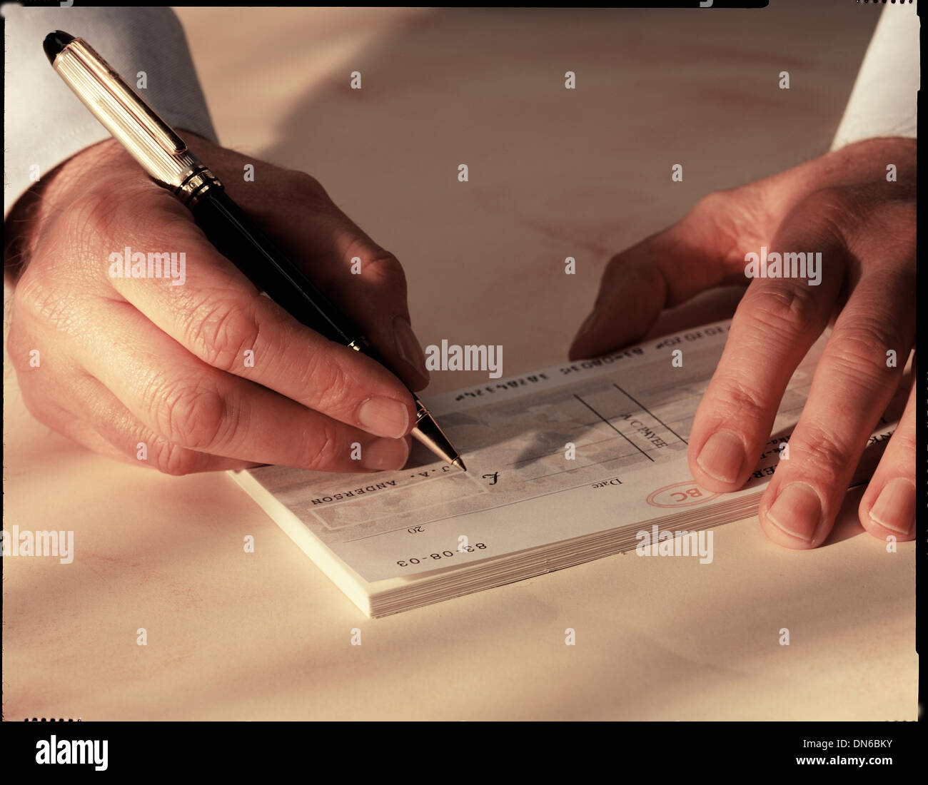Writing a cheque Stock Photo - Alamy