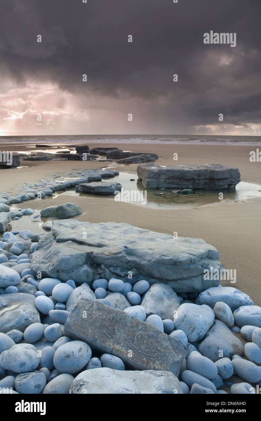 Pebbles and Rocks on the beach at Southern Down, Wales. The rain cloud ...