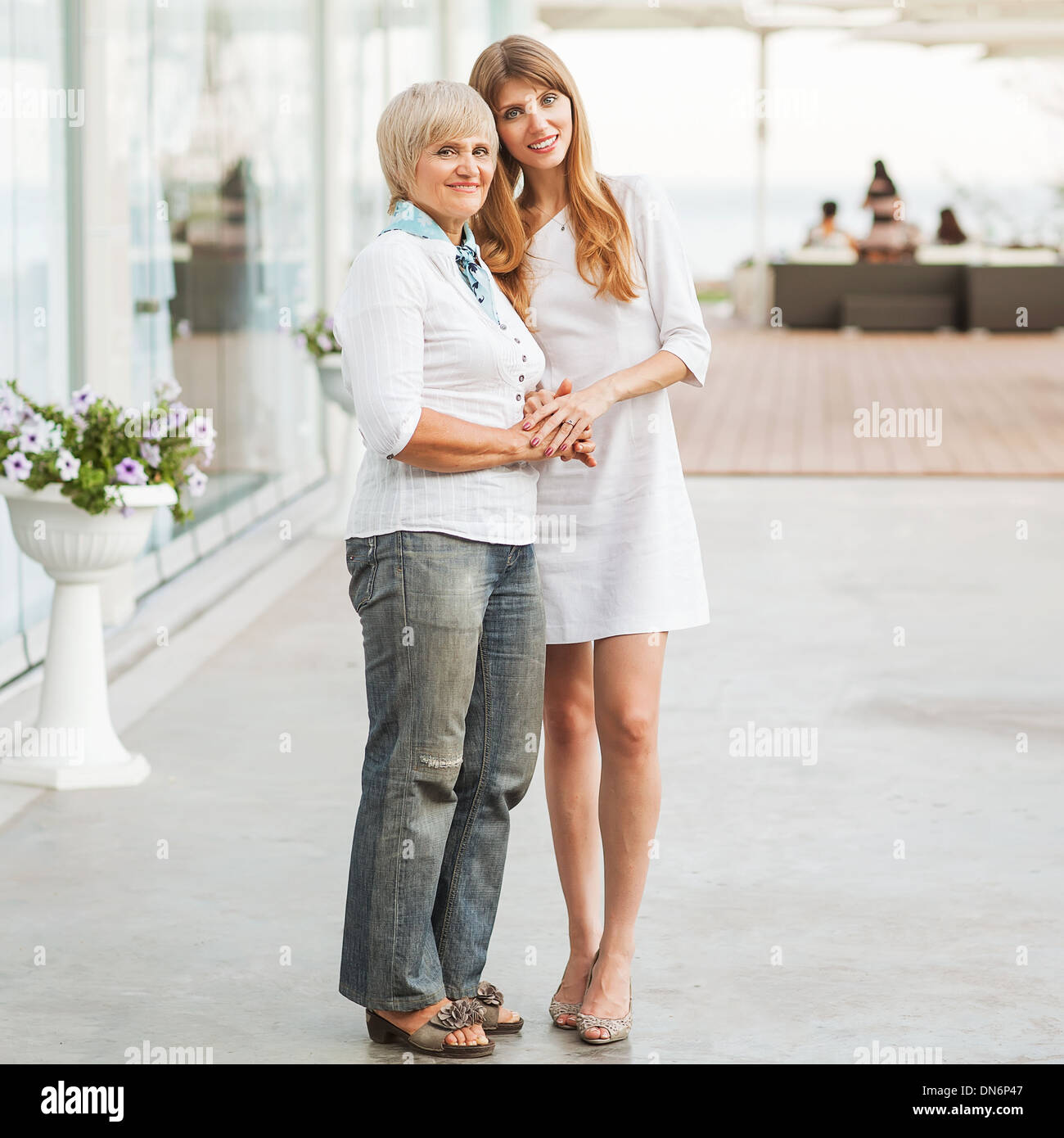 Adult mother and daughter standing at the large glass case holding ...