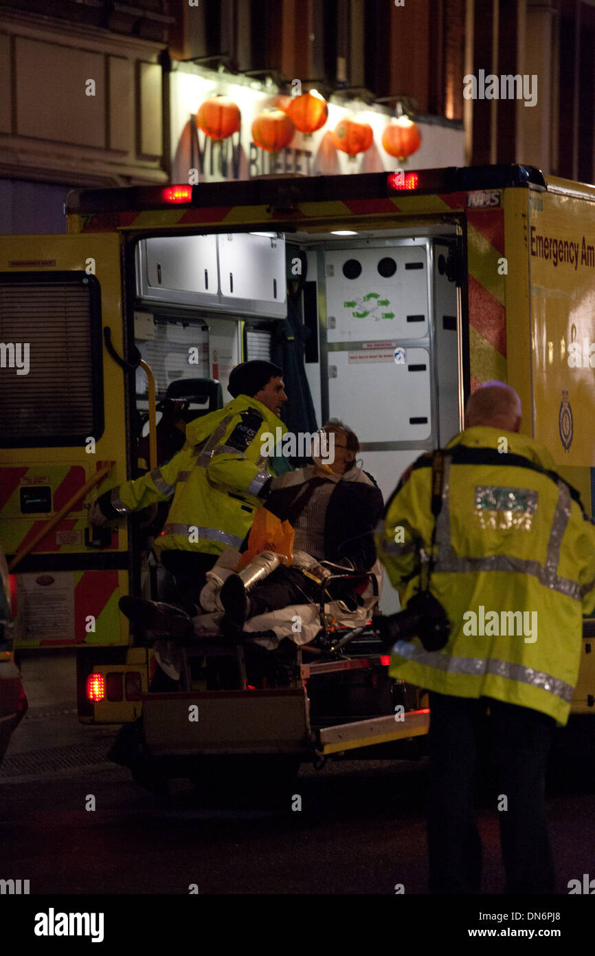 London, UK. 19th Dec, 2013. An injured lady is carried to a waiting ...