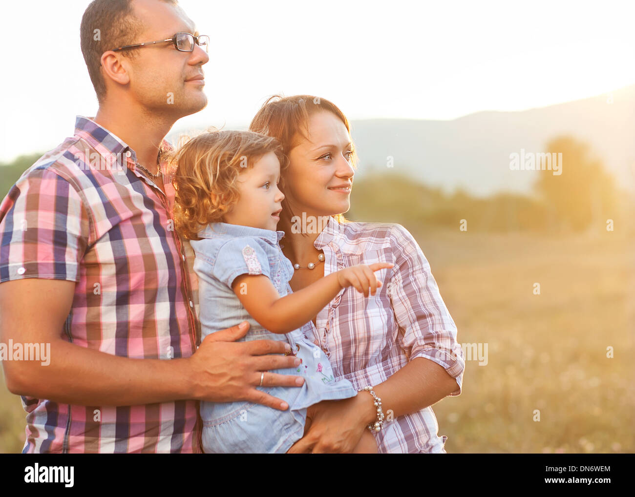 Happy mother, father and daughter in sunset Stock Photo - Alamy